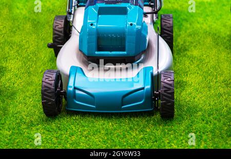Turquoise lawn mower on grass Stock Photo - Alamy