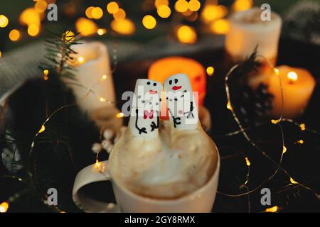 Marshmallow snowmans with cup of coffee, bokeh lights, christmas decoration. High quality photo ...