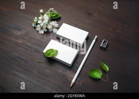 Blank business cards, pencil, sharpener and spring flowers on wood ...