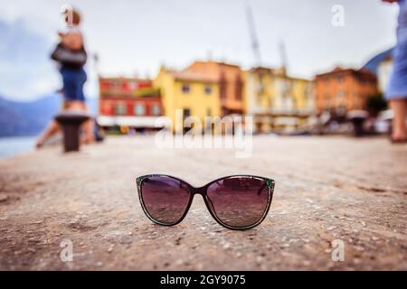 Italian harbour scene: Sunglasses on the stony ground Stock Photo - Alamy