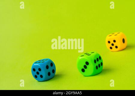 Three colored dice on green background. Copy space Stock Photo - Alamy