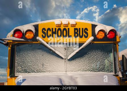 School bus covered with fresh snow. Minibus under the snow. Sleet slush ...