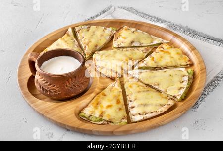 Quesados - Mexican appetizer garnished with sour cream Stock Photo - Alamy