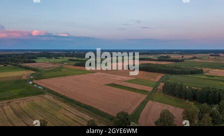 Sunset aerial landscape of filds and meadows with distant clouds in ...