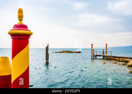 Old stone jetty at the tip of San Vigilio, on Lago di Garda with ...