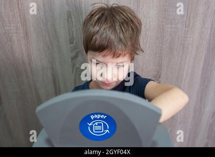 Child boy throwing paper to waste bin for paper at home. Education ...