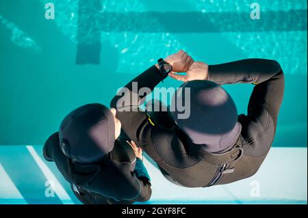Female diver and male divemaster in scuba gear, dive lesson in diving ...