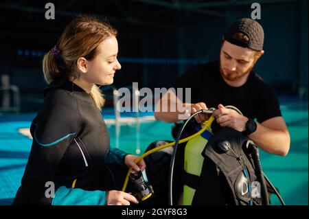 Male instructor in suit explains how scuba gear works, diving school ...