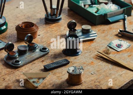 Components of a clock on a watchmakers workbench with a coiled spring ...