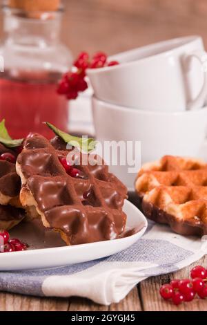 Waffles with chocolate icing and red currant Stock Photo - Alamy