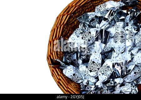 White and silver packaged Christmas chocolate candies in a brown wicker ...