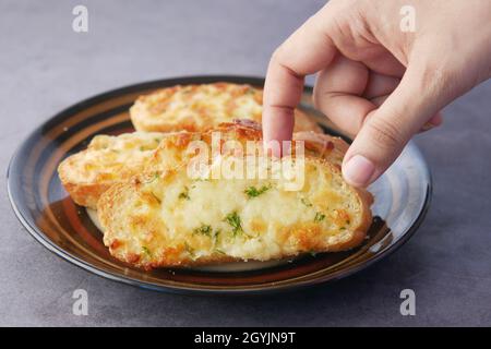 hand pick a garlic bread on a plate Stock Photo - Alamy