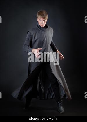 A villain with a red lightsaber, a young man in a long robe does ...