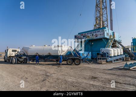 Oilfield workers transferring dry cement from their truck to the oil ...
