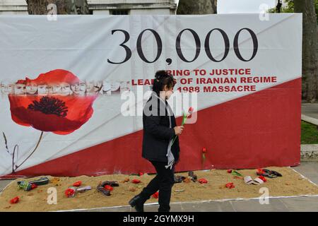 An Iranian woman walks past a banner showing head of the paramilitary ...