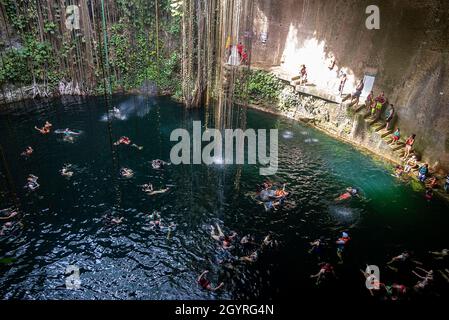 Tourists taking bath in cenote a natural lagoon amidst rocks and ...