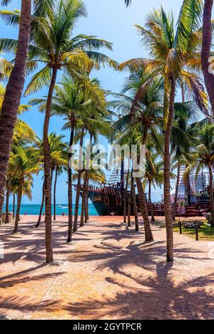 Coconut trees against pirate ship moored on harbor by sea Stock Photo ...