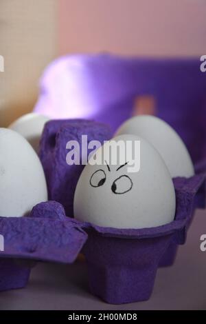 Four Easter eggs with funny faces and gray crocheted hats with bunny ...