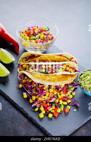 Vegetarian tacos with sweet corn, purple cabbage and tomatoes on a ...