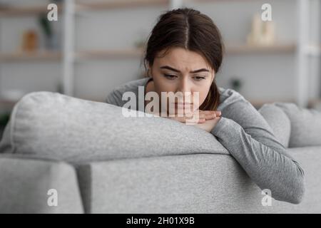 Indifferent caucasian young female suffering from depression, touching ...