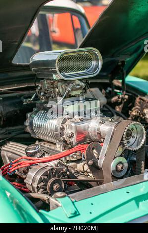 Sports car engine with turbine. An open race car hood on a pit stop ...