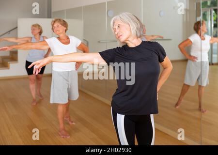 Aged woman practicing ballet dance moves in choreographic studio Stock ...