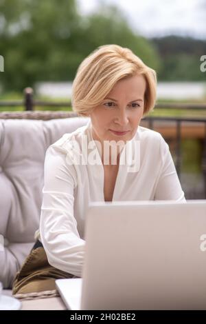 Front view concentrated pleasant mature older woman looking at computer ...