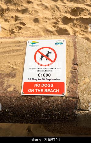 White and red sign screwed to a concrete wall. In the middle of the ...