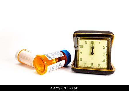 Alarm clock with pill bottles on table in room, closeup Stock Photo - Alamy