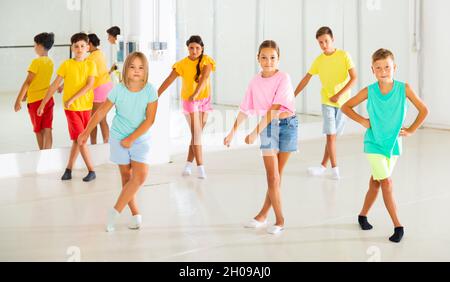 Happy tweens dancing during group class in choreographic studio Stock ...