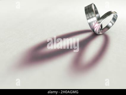 A pair of white wedding rings resting on an isolated white suface ...