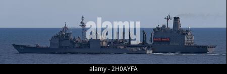 USNS Matthew Perry steams alongside the aircraft carrier USS Nimitz in ...