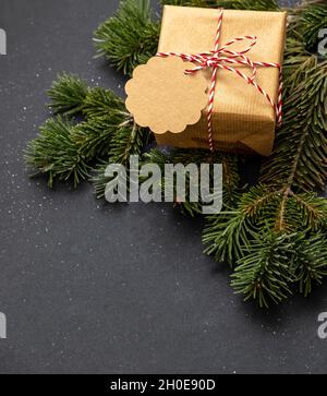 Black and kraft christmas gift with a blank tag mockup on a black ...