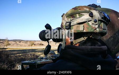 An Opposing Forces (OPFOR) soldier uses a night vision system, attached ...