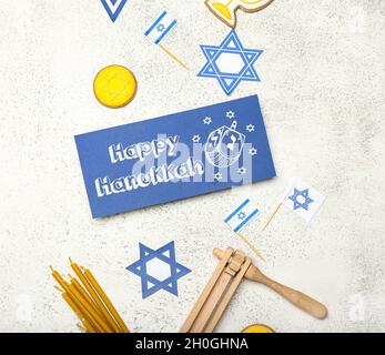 Different symbols of Hanukkah and greeting card on light blue ...