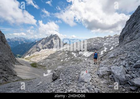 Hiker crossing a scree field, hiking to the Patenkirchner Dreitorspitze ...