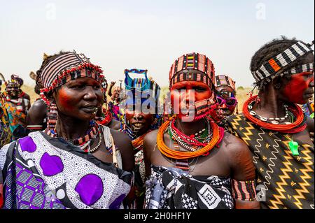 Traditional dressed women of the Jiye tribe dancing and singing ...