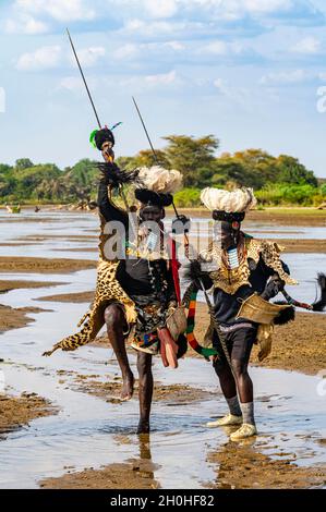 Men from the Toposa tribe posing in their traditional warrior costume ...