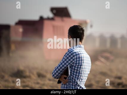 Farmer standing in soybean field looking at notebook and drone Stock ...