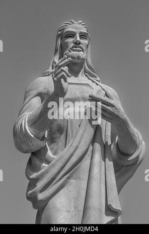 A grayscale shot of an old statue of Jesus Christ with a blurred ...