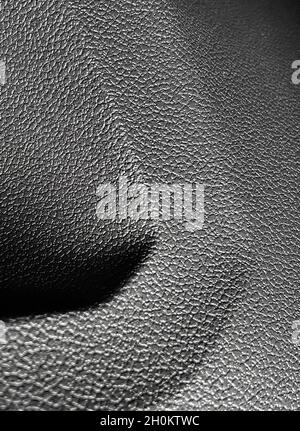 Closeup of the bumpy patterned gray plastic surface of a car's door ...