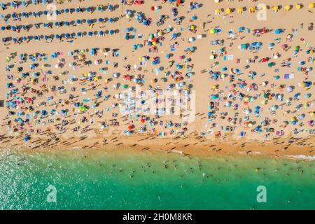 Drone shot of many people enjoying the beach and the ocean - vacation ...