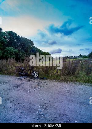 Burned out bike dumped onto recreational land, environmental pollution ...