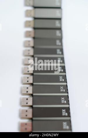 Many black USB sticks in a row with white background. Production of ...