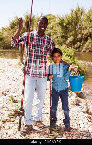 Man and boy with bucket of catch Stock Photo - Alamy