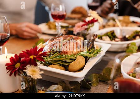 Multiracial happy friends eating turkey during thanksgiving dinner at ...