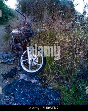 Burned out bike dumped onto recreational land, environmental pollution ...