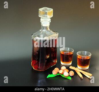 Nut liqueur with cinnamon and mint, strong homemade alcohol on a black ...