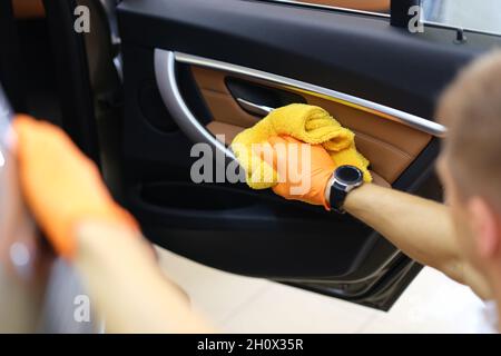 Gloved handyman wipes car doors inside cabin closeup Stock Photo - Alamy