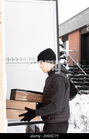 Man unloading parcels from car trunk Stock Photo - Alamy